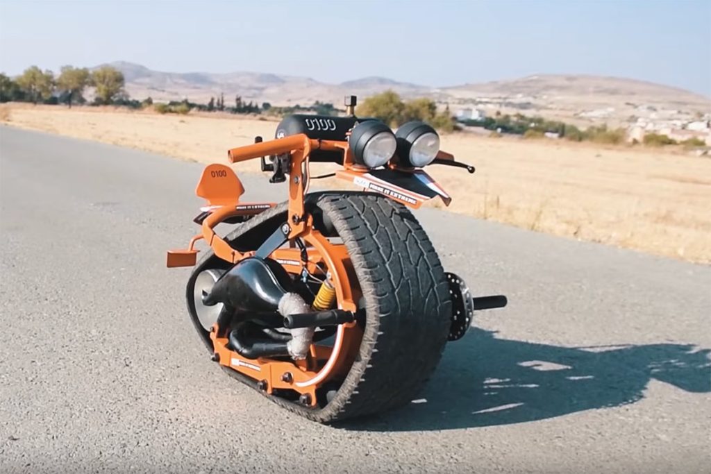 Single-wheel, recycled-tire mini motorbike leans back for wheelies