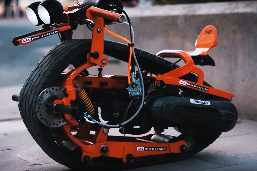 Single-wheel, recycled-tire mini motorbike leans back for wheelies