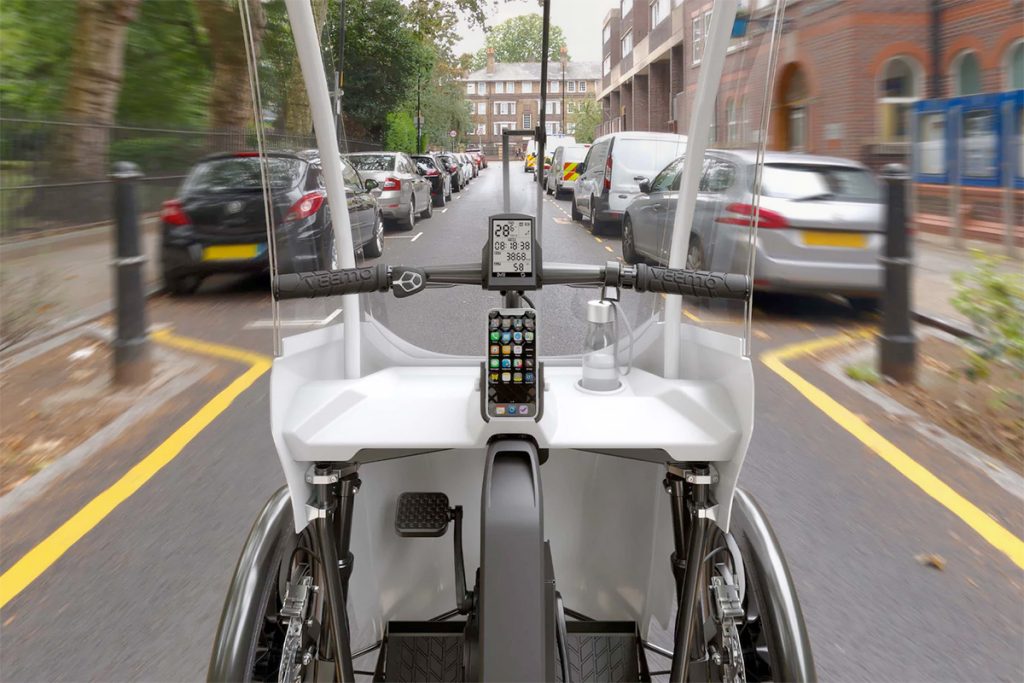 Semi-enclosed, three-wheeled, pedal-powered vehicle with electric assist