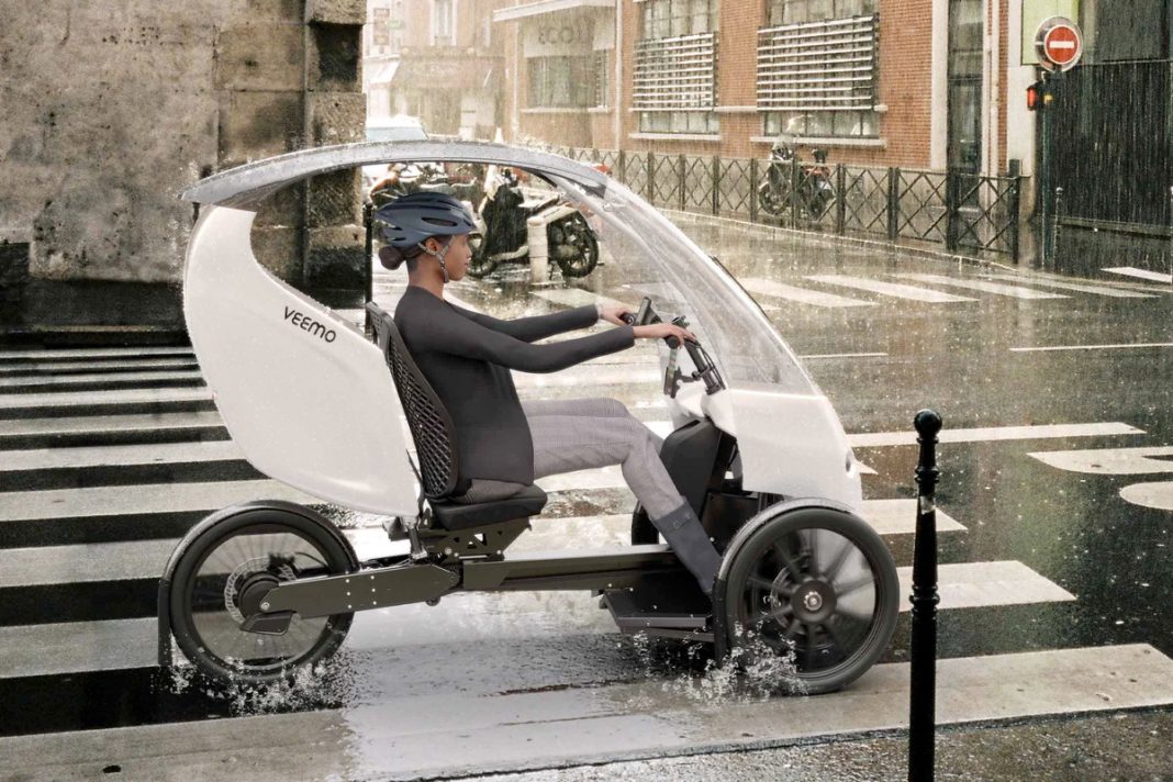 Semi-enclosed, three-wheeled, pedal-powered vehicle with electric assist