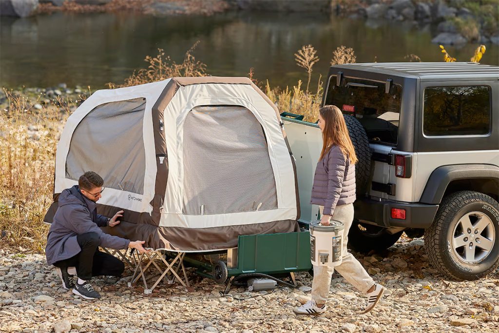 Hitch-mounted tent rolls out and inflates for elevated camping