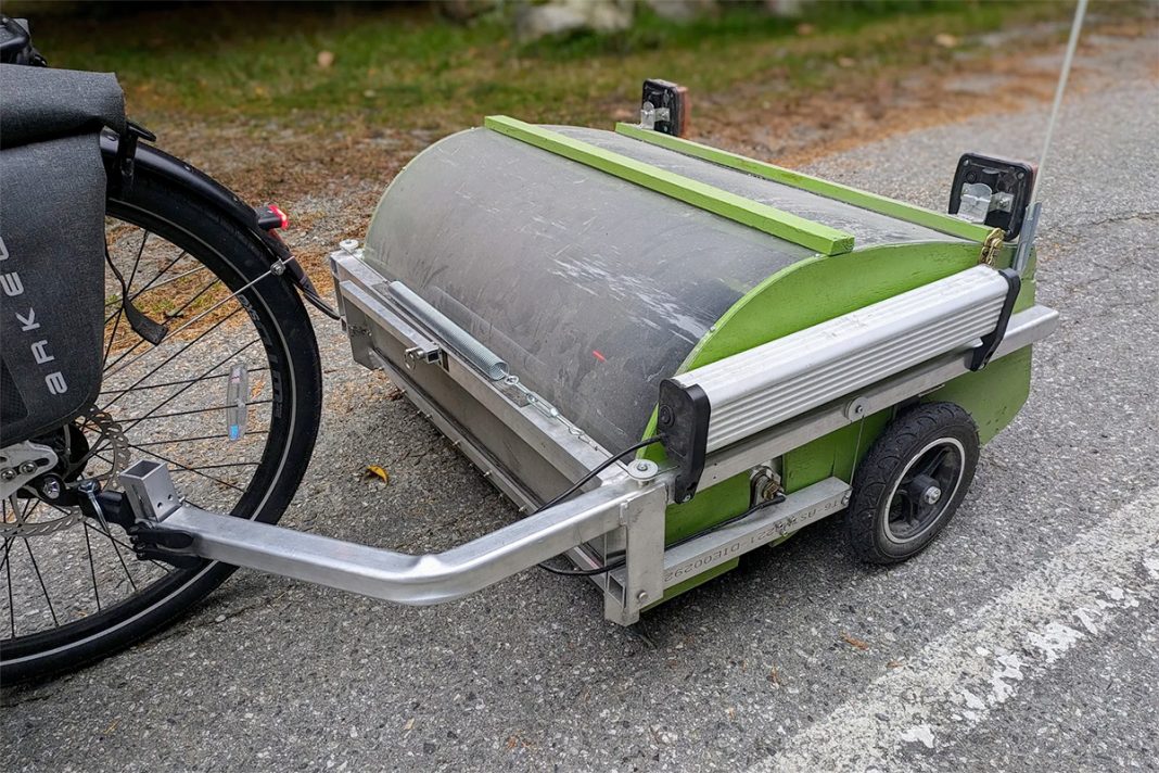 Motorized trailer sweeps away glass and debris from bike lanes