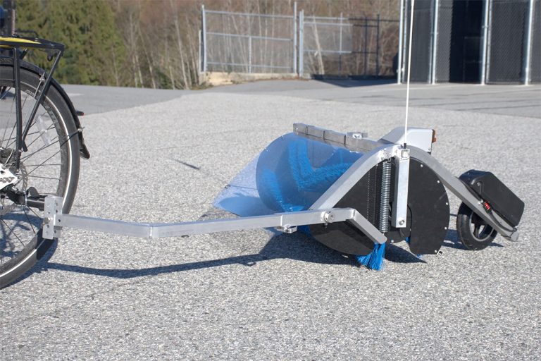 Motorized trailer sweeps away glass and debris from bike lanes
