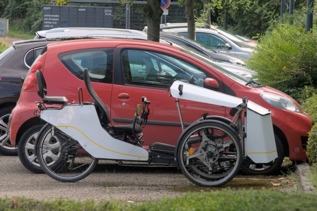 Semi-enclosed recumbent e-trike is a blend of bicycle and car